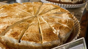 Uma mesa com sobremesas, incluindo uma Tarta Banofee, um doce de banana e creme, e outras opções.
