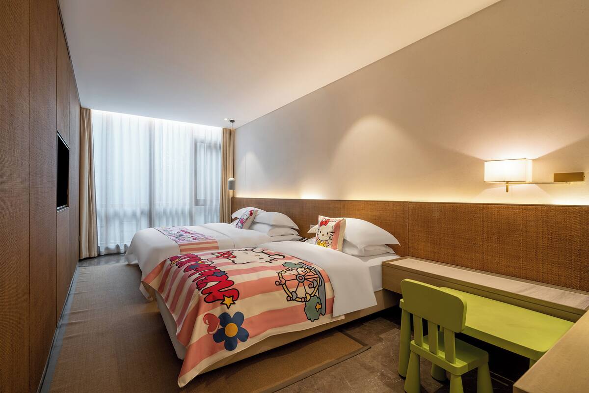 Quarto de hotel com uma cama, uma mesa e uma cadeira.