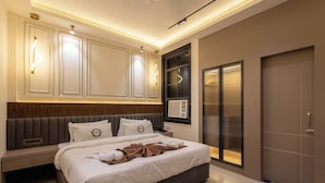 Quarto moderno com cama grande, cabeceira embutida, mesas de cabeceira e guarda-roupa.