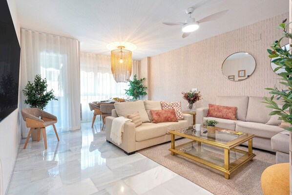 Uma sala de estar moderna com sofá, mesa de centro e área de jantar.