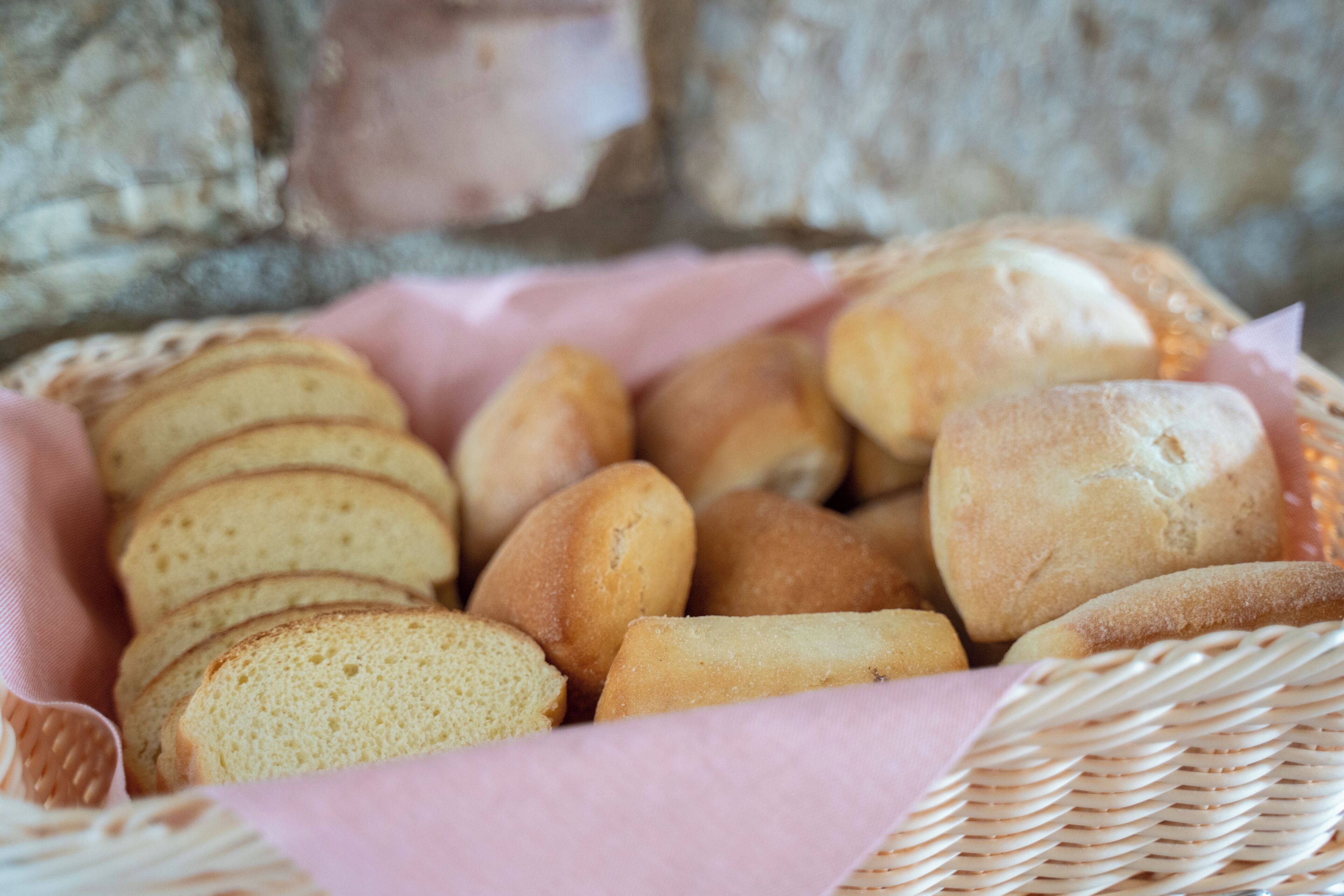 Uma cesta com pães e doces variados.