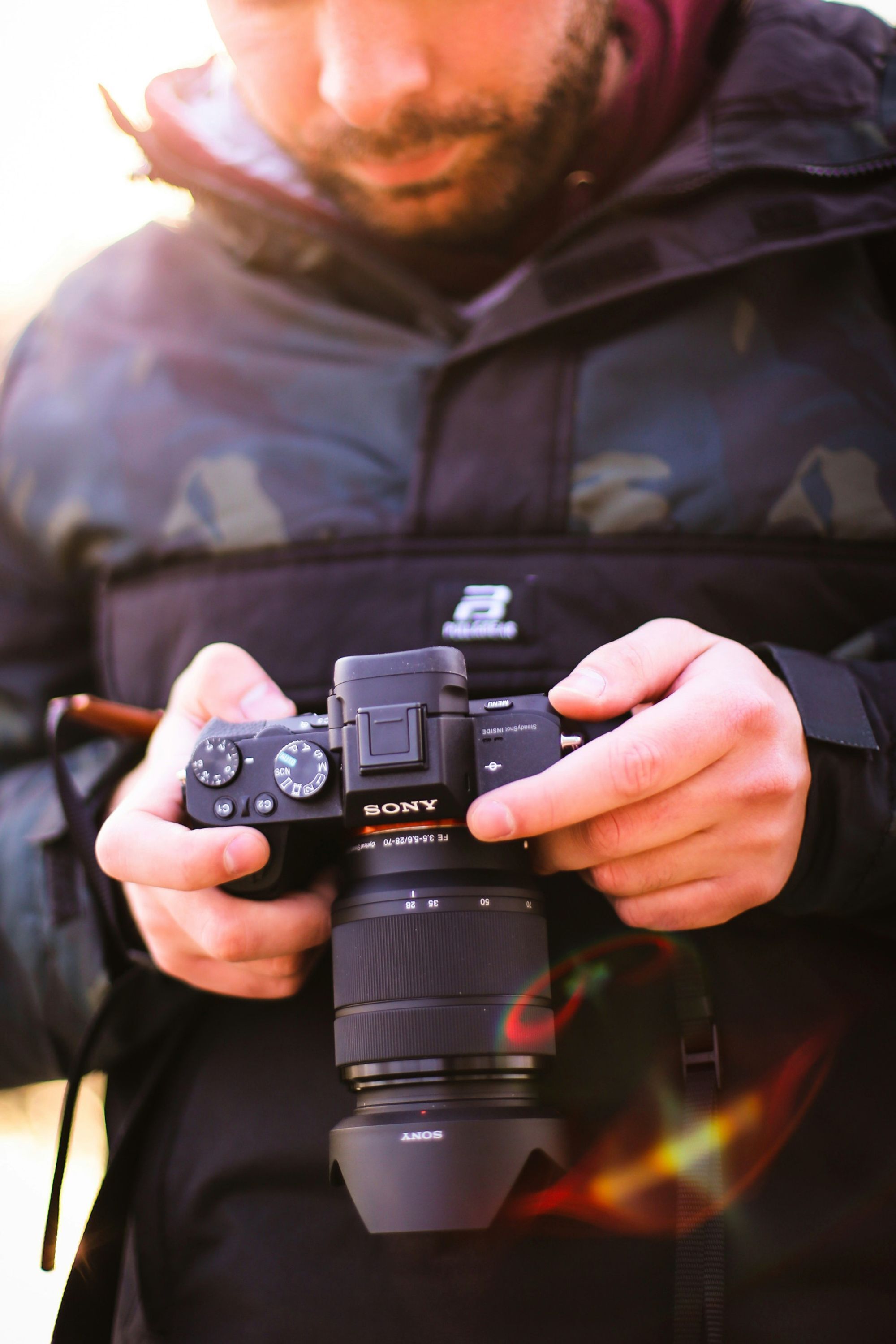 Uma pessoa segurando uma câmera Sony com lente.