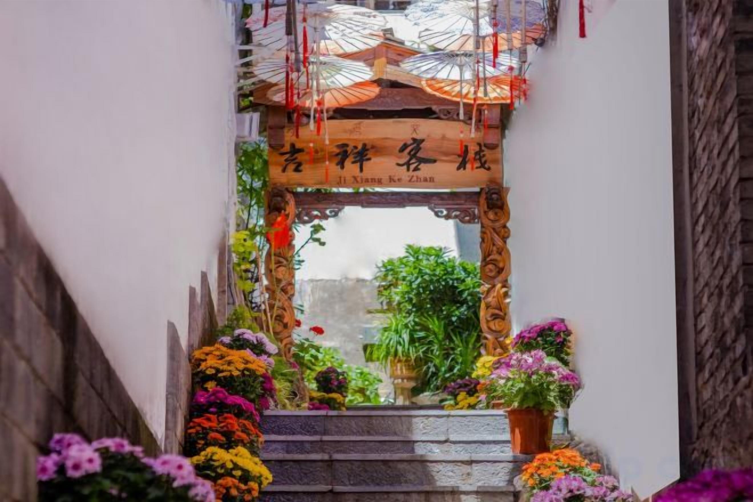 Escadaria que leva a um portão chinês tradicional com detalhes florais.