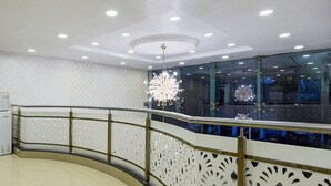 Um interior moderno com varanda curva, grades decorativas e um candelabro.