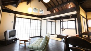 Quarto em estilo japonês tradicional, com tatames, teto de madeira baixo e portas deslizantes shoji.