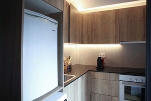 Apartamento Familiar, 1 quarto, Vista para a cidade | Cozinha privada | Um frigorífico, um micro-ondas, um forno, uma placa de cozinha 