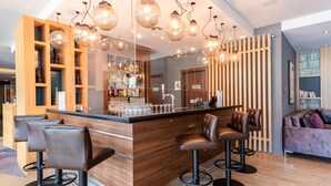 Uma área de bar moderna com banquetas de madeira, um balcão com utensílios de bar e uma estante para vinhos.
