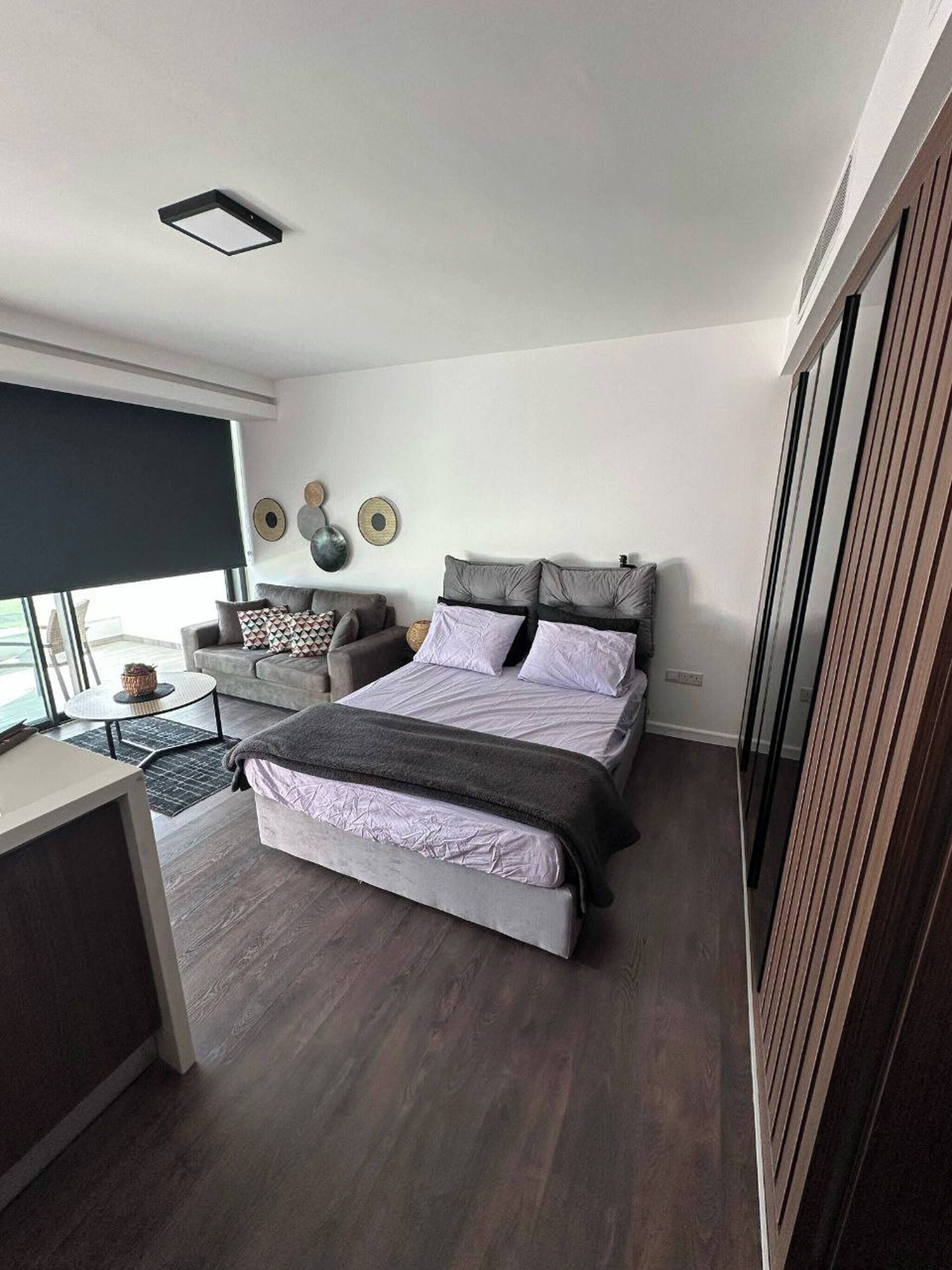 Um quarto moderno com uma cama grande, uma escrivaninha e uma vista pela janela.