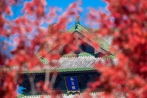 Um edifício tradicional com telhado em telhas e uma faixa azul com texto branco.