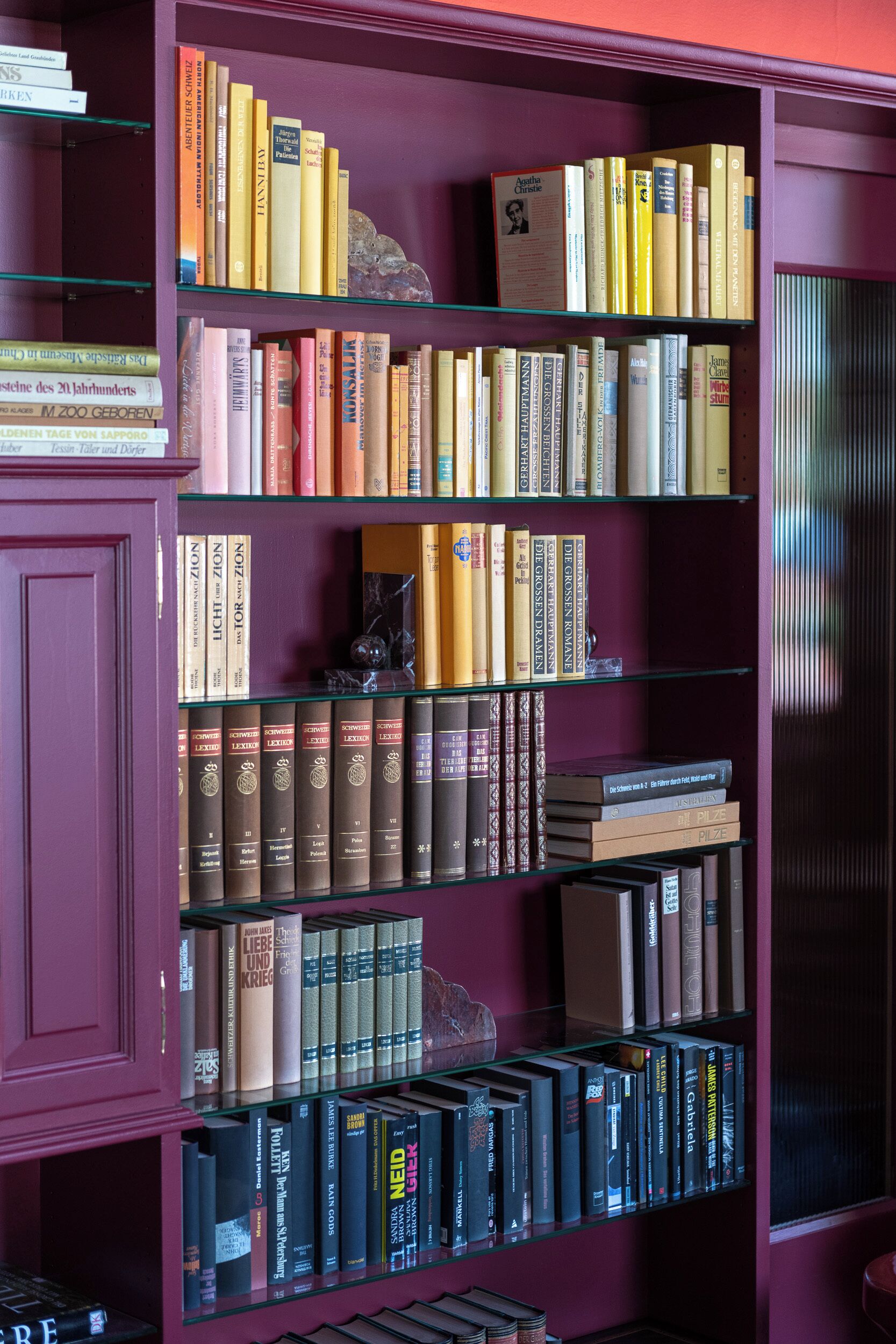 Uma estante com vários livros, incluindo alguns com títulos e autores visíveis.