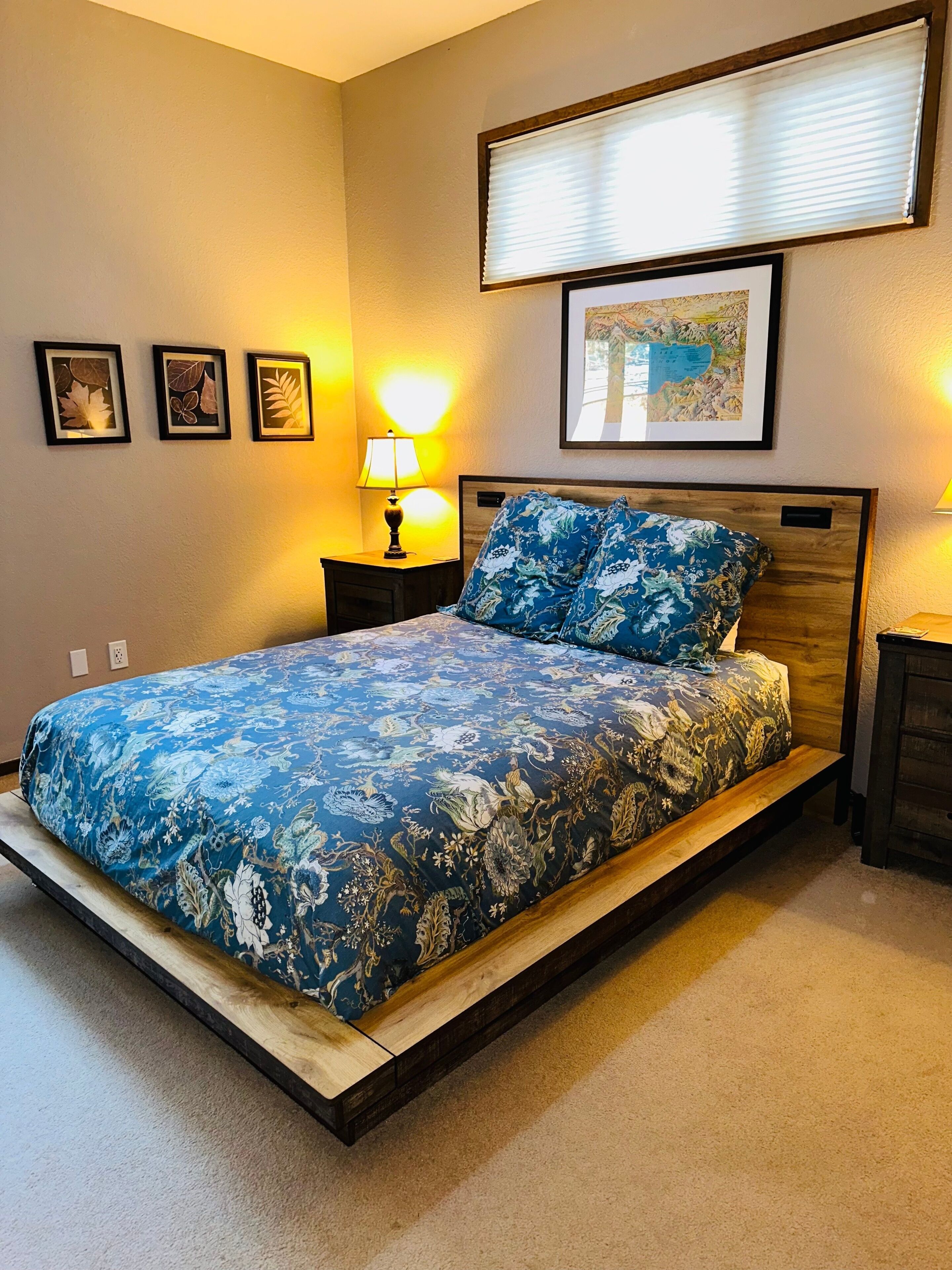 Quarto com cama, obras de arte emolduradas e um mapa na parede.