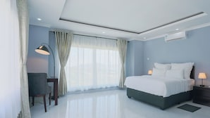 Quarto de hotel moderno com uma cama grande, uma escrivaninha e uma cadeira.