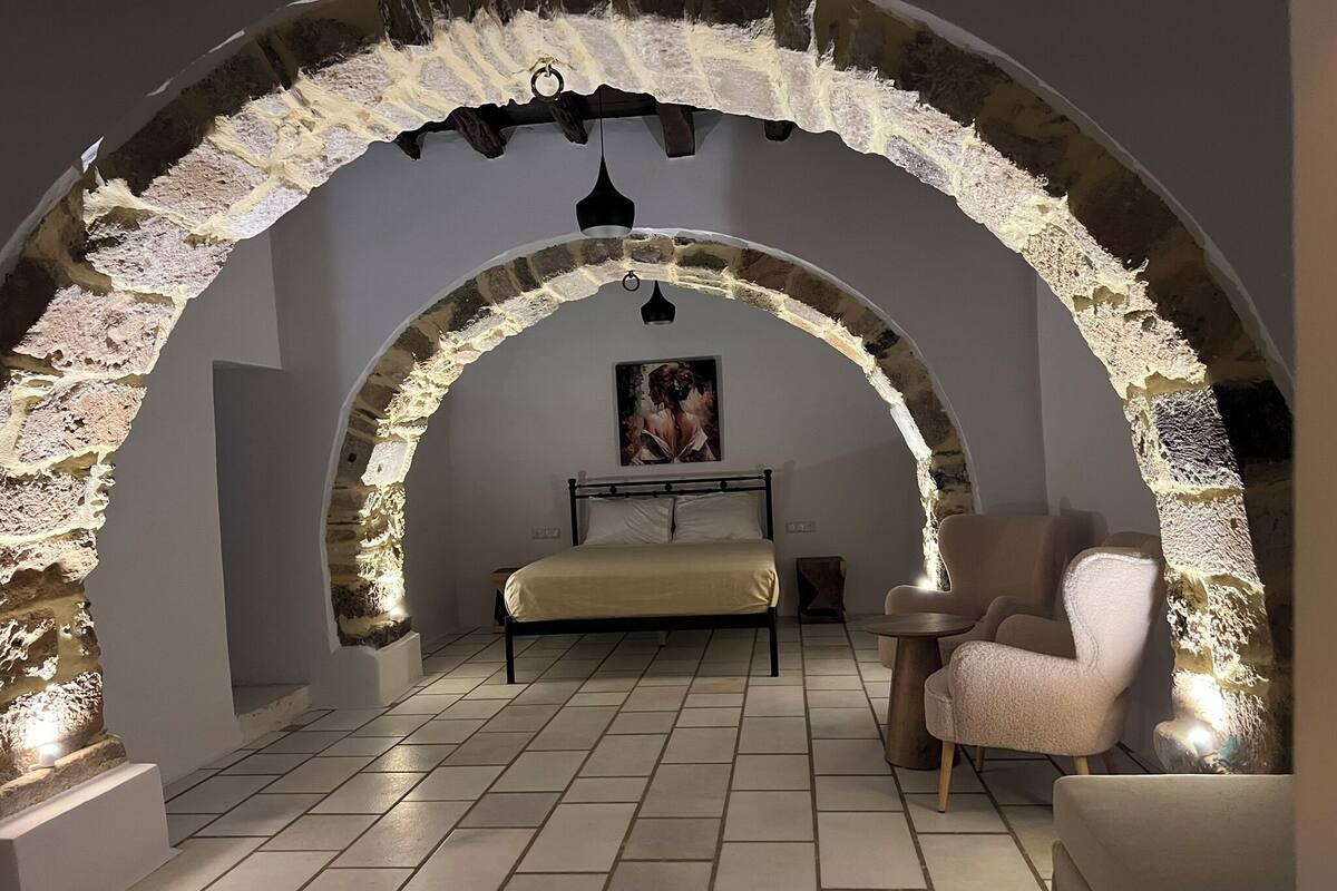 Quarto com uma cama, uma cadeira e um quadro na parede.