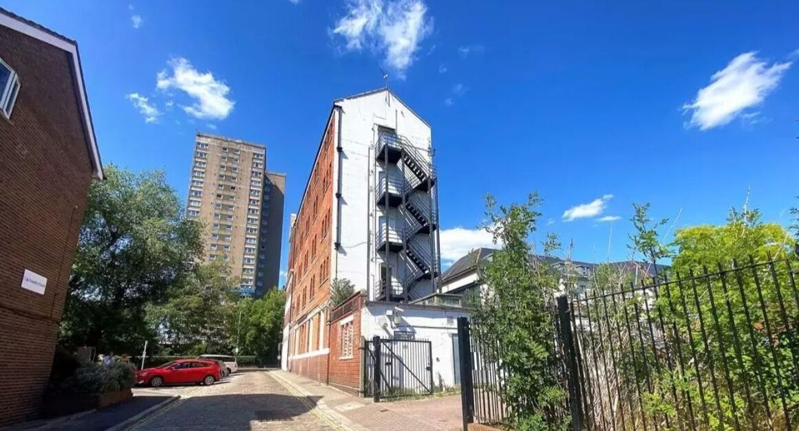 Um edifício com uma escadaria imponente e fachada de tijolos.