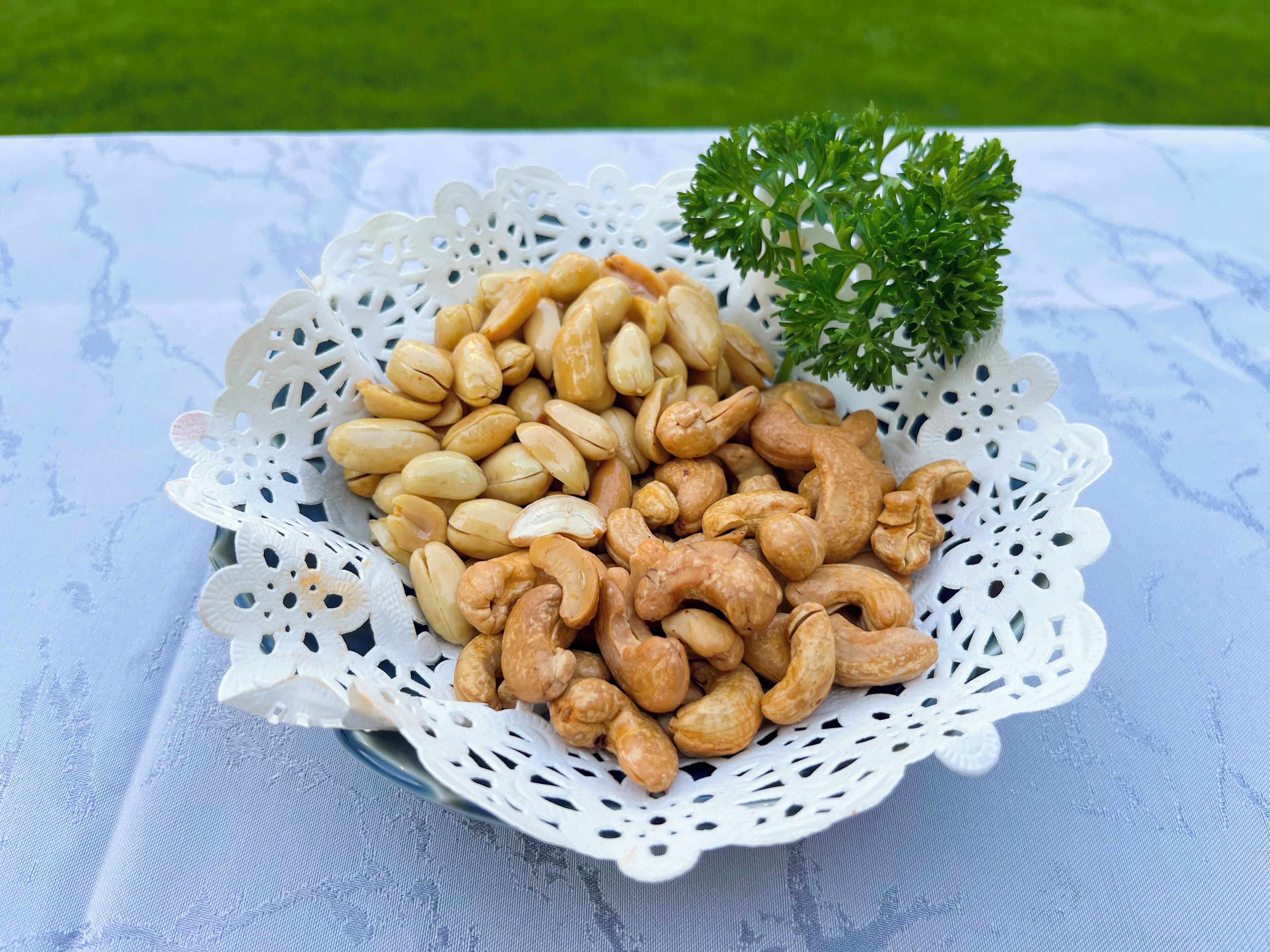 Um prato de mix de frutos secos sobre um bordado de renda branco.