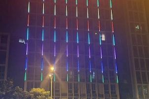 Fachada de prédio com fitas verticais de luz.