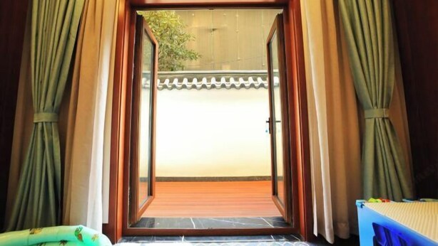 Quarto com porta de vidro deslizante que dá para uma varanda, piso de madeira e chão ladrilhado.