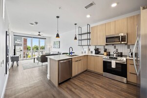 Cozinha moderna com ilha central, eletrodomésticos de aço inoxidável e vista para o exterior.