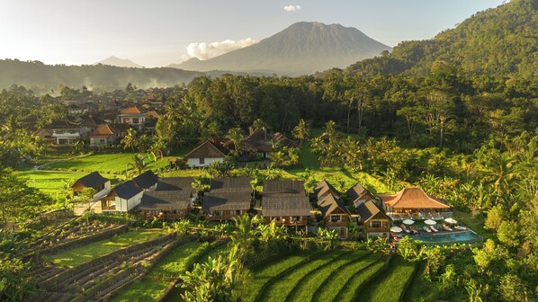 Um resort com arquitetura tradicional, jardins em terraços e área de piscina.