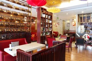 Um restaurante com móveis de madeira, adega e estante de livros.