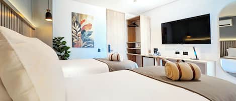 Quarto de hotel moderno com uma cama grande, televisão, secretária com máquina de café e guarda-roupa.