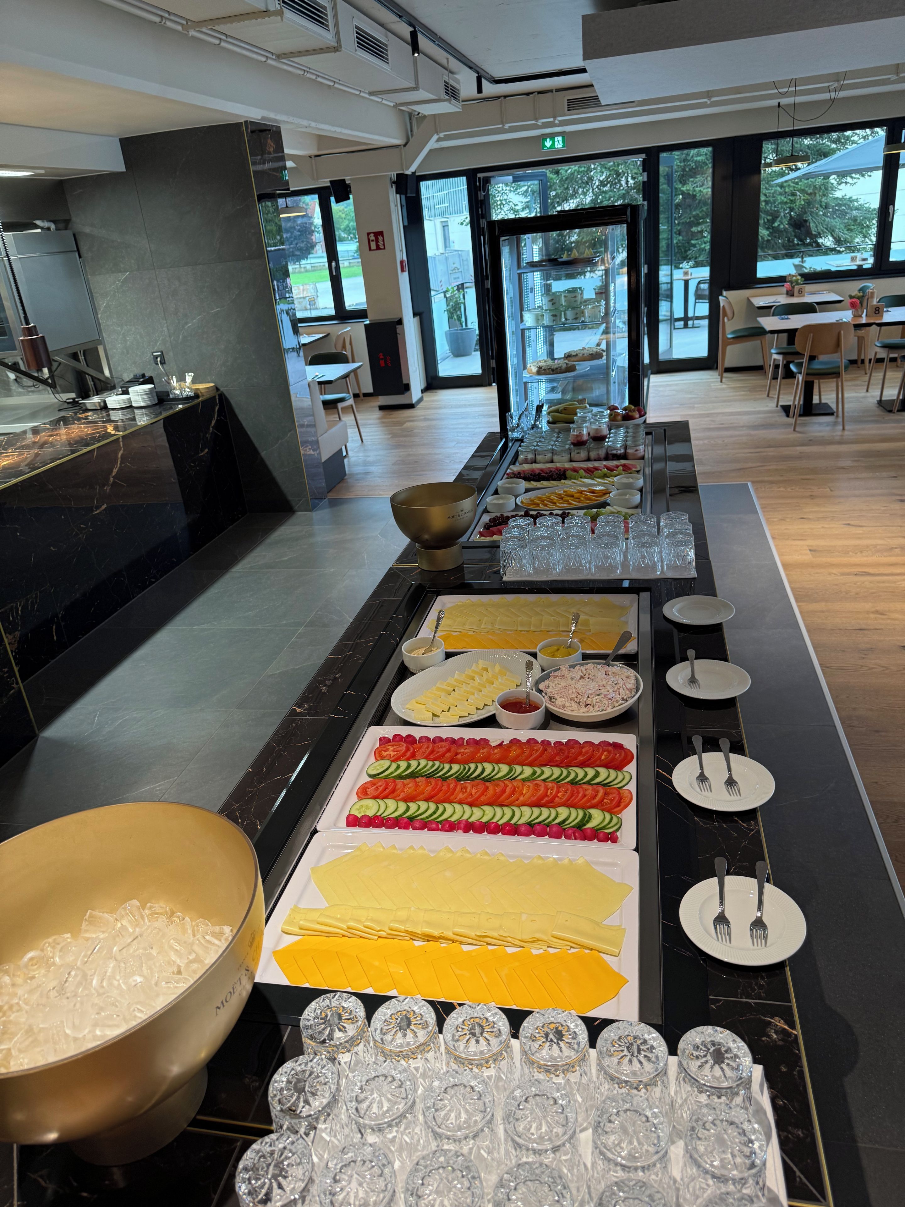 Disposição de buffet com diversos alimentos e utensílios.