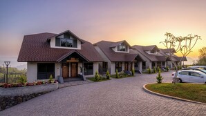 Um edifício residencial moderno com várias casas, um caminho de entrada pavimentado e uma área de estacionamento.