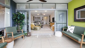 Ampla sala de estar com sofá, cadeiras e mesa de jantar.