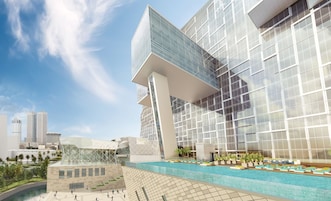 Um hotel moderno com fachada de vidro extensa, piscina e vista para o horizonte da cidade.