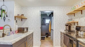 Cozinha moderna com ilha central, eletrodomésticos embutidos e vista para a sala de jantar.