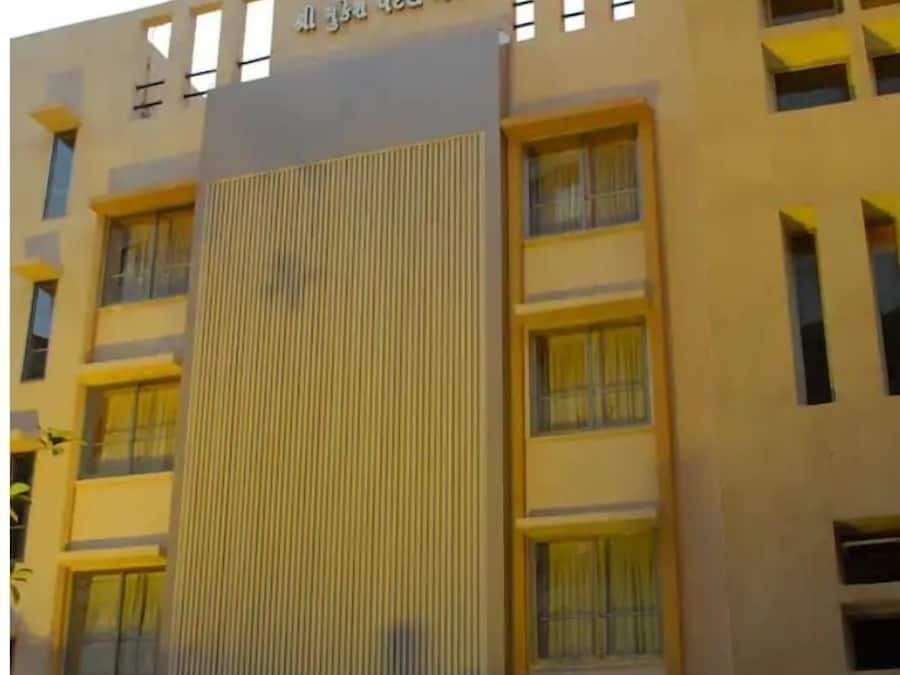 Um edifício com fachada bege, várias janelas e um painel vertical central.