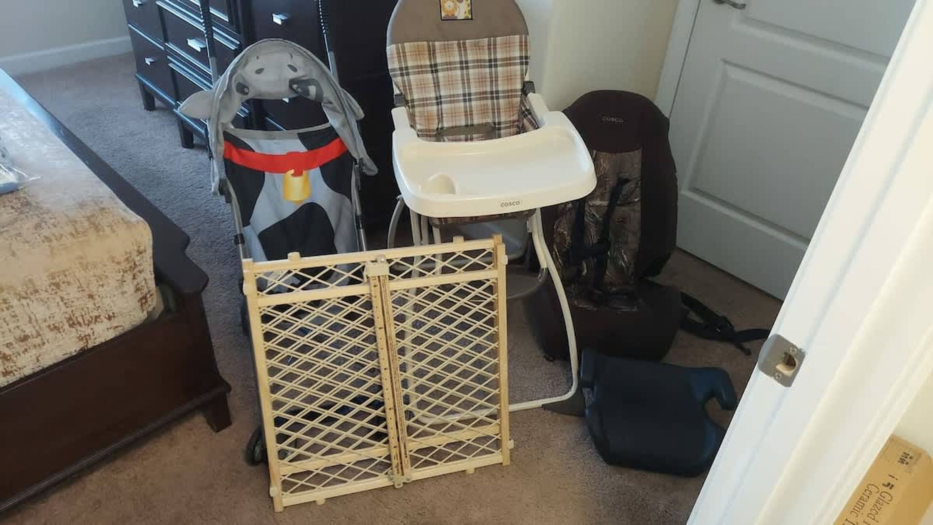 Quarto com carrinho de bebê, cadeirinha, portão e mala.