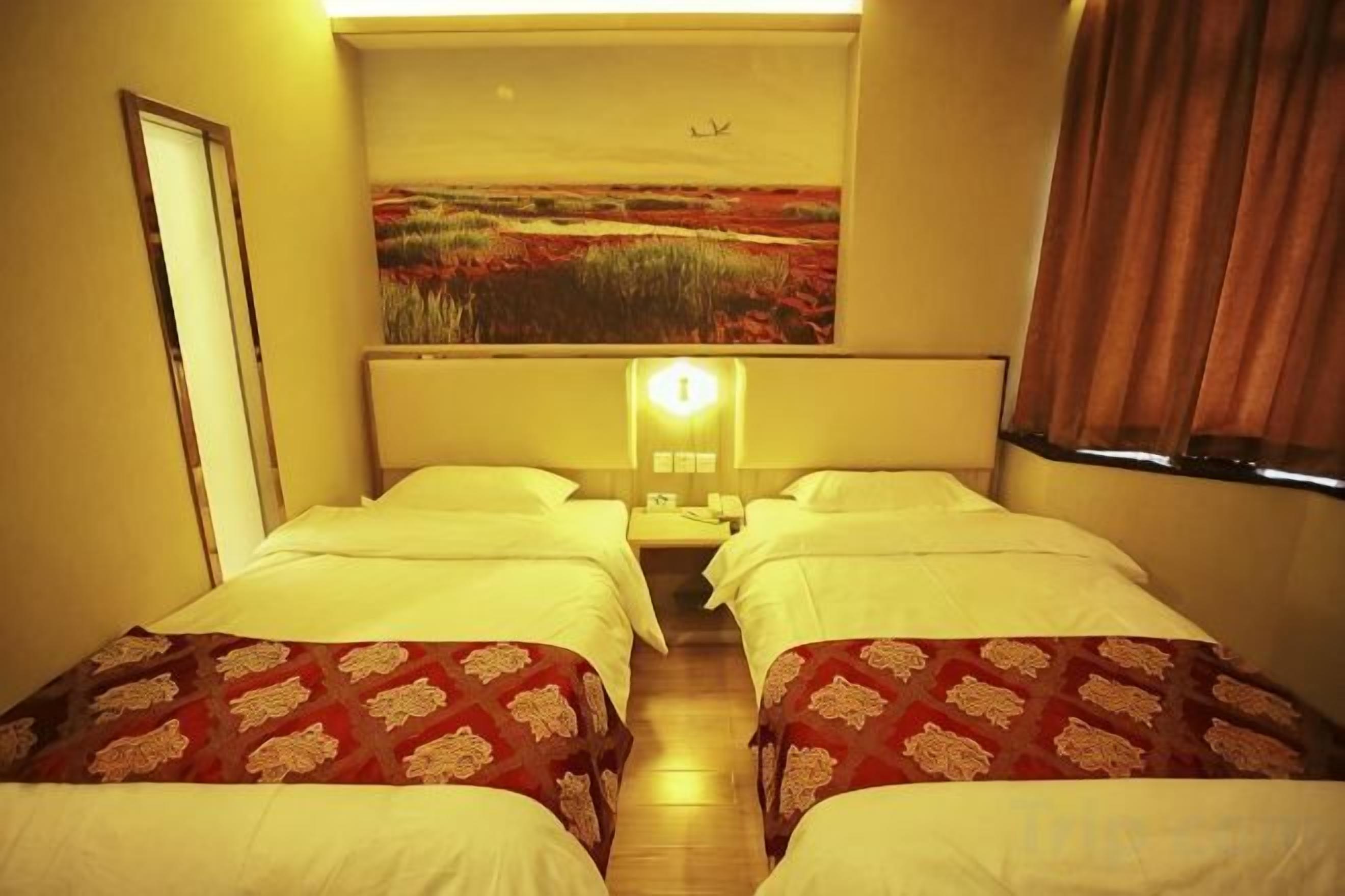 Quarto de hotel com duas camas de solteiro, um quadro grande na parede e uma janela com cortinas.