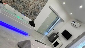 Casa de banho moderna com soalho de mármore, banheira, toalha e pétalas de rosa no chão.