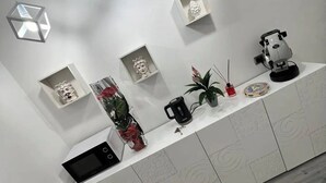 Uma cozinha moderna com micro-ondas, cafeteira e objetos decorativos no balcão.
