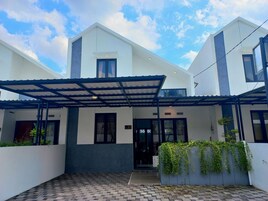 Um edifício moderno com entrada coberta, um pátio ladrilhado e uma placa indicando a sala K4.