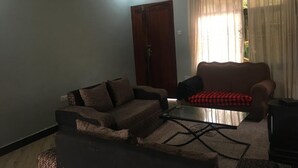 Uma sala de estar com sofá, mesa de centro e televisão.
