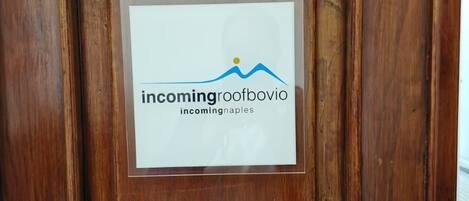 Uma porta de madeira com uma placa que diz 'incoming roofbovio' e 'incoming naples'.