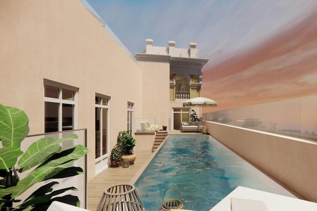 Uma área de piscina moderna, com vista desimpedida da piscina, uma espreguiçadeira e uma mesinha.