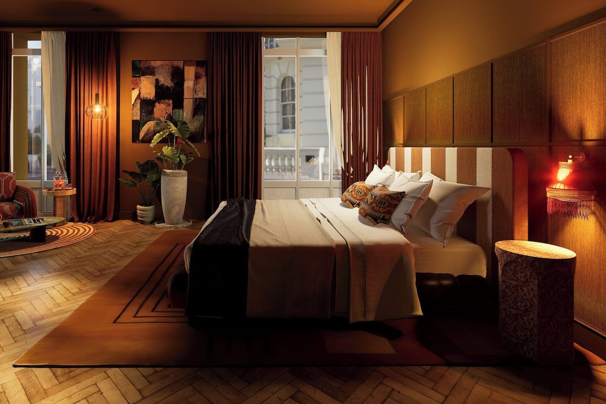 Quarto de hotel moderno com uma cama grande, um sofá, uma mesa de centro e vista para a cidade.