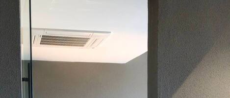 Quarto moderno com escrivaninha, cadeira e luminária.