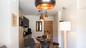 Um espaço compacto com área de refeições, cozinha compacta e sofá.