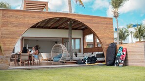 Uma casa moderna com fachada de madeira, área de estar coberta ao ar livre e piscina.