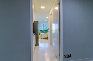 Corredor que dá para um quarto com vista para o exterior.