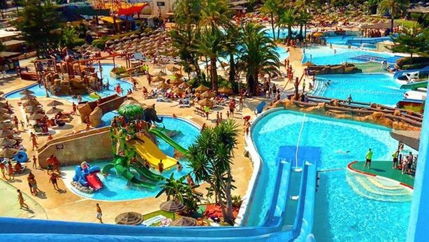 Um parque aquático com várias piscinas, toboáguas e um escorregador gigante.