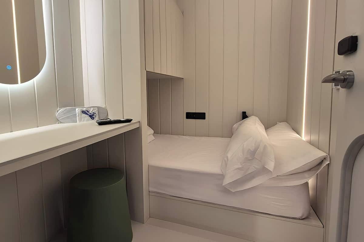 Casa de banho moderna com toucador, espelho, sanita e cama.