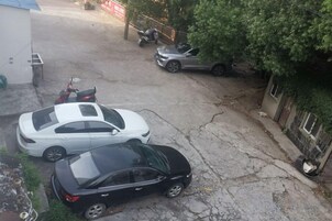 Uma área de estacionamento com dois carros e uma motocicleta.