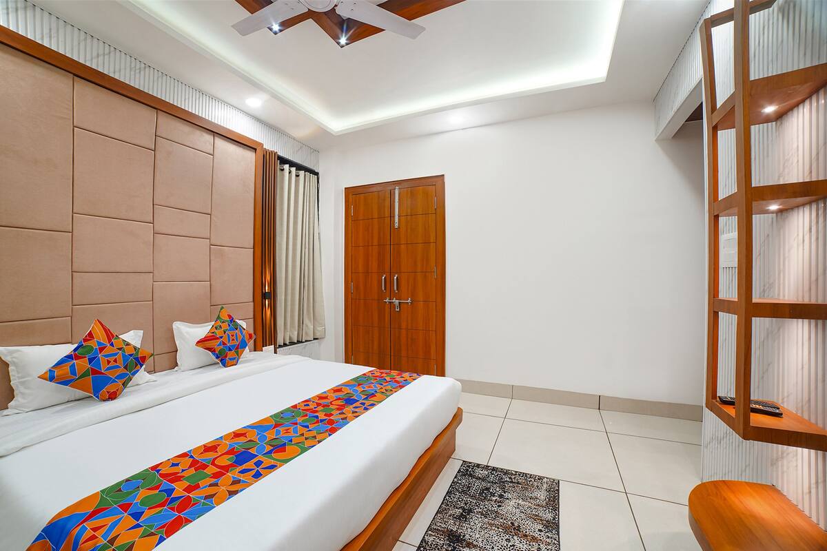 Um quarto moderno com uma cama grande, um guarda-roupa de madeira e um ventilador de teto.