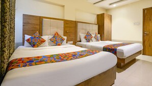 Quarto de hotel com duas camas, cabeceiras de madeira e ventilador de teto.