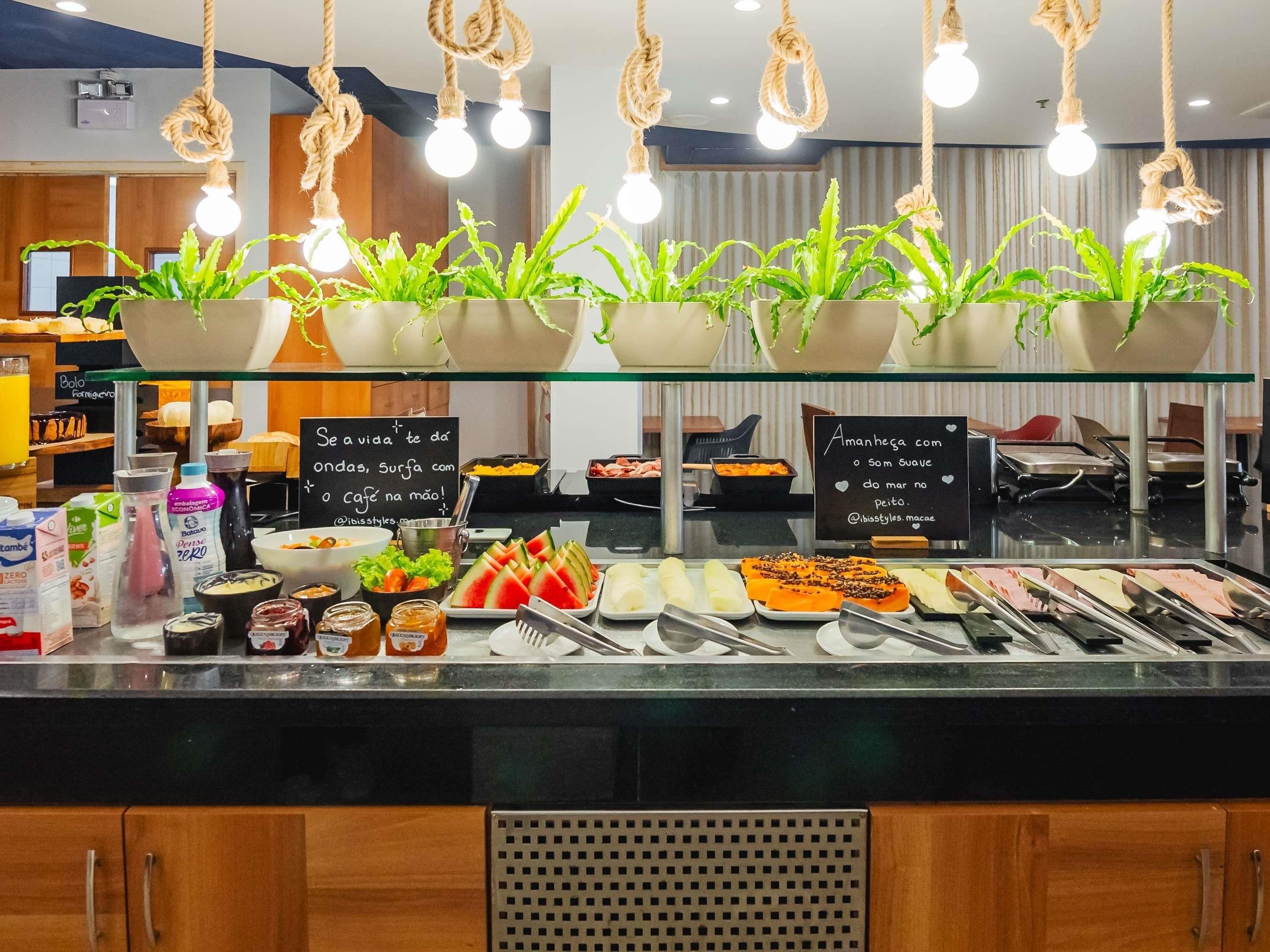 Um balcão de buffet com diversos alimentos e acompanhamentos.